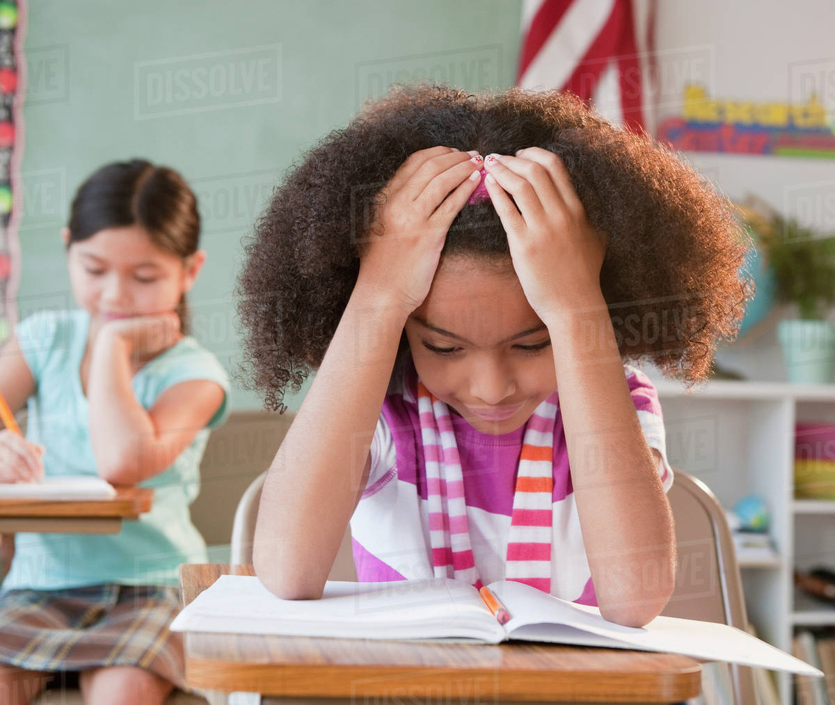 School girl reading book in classroom - Royalty-free Stock Photo | Dissolve