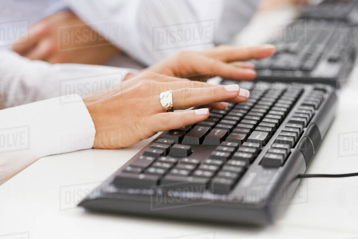 Hispanic woman typing on keyboard - Stock Photo - Dissolve
