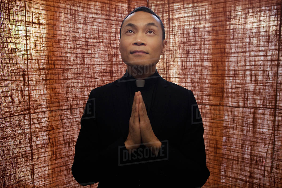 Pacific Islander priest praying - Stock Photo - Dissolve