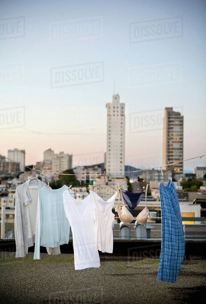Laundry on clothes line on urban rooftop - Stock Photo - Dissolve