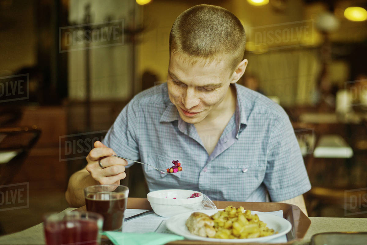 Caucasian man eating lunch at table - Royalty-free Stock Photo | Dissolve