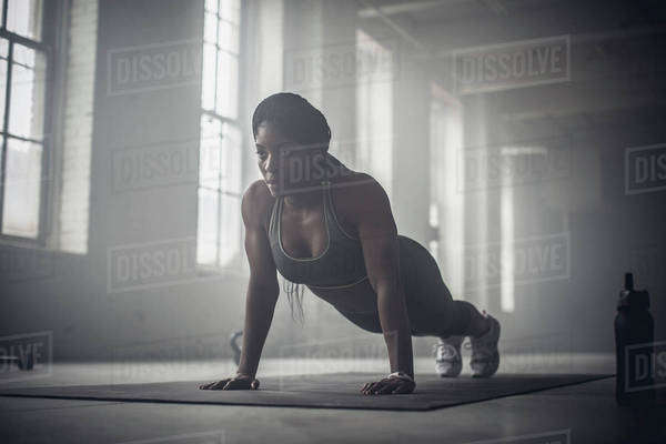 Black woman doing push-ups in dark gym - Royalty-free Stock Photo ...