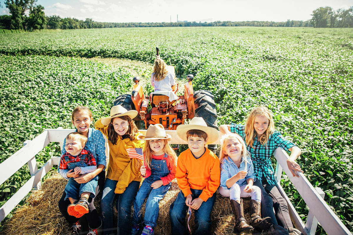Caucasian family smiling on hay ride - Royalty-free Stock Photo | Dissolve
