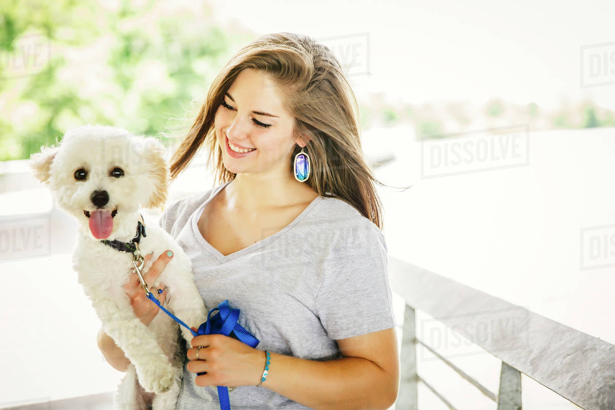 Caucasian woman carrying dog outdoors - Royalty-free Stock Photo | Dissolve