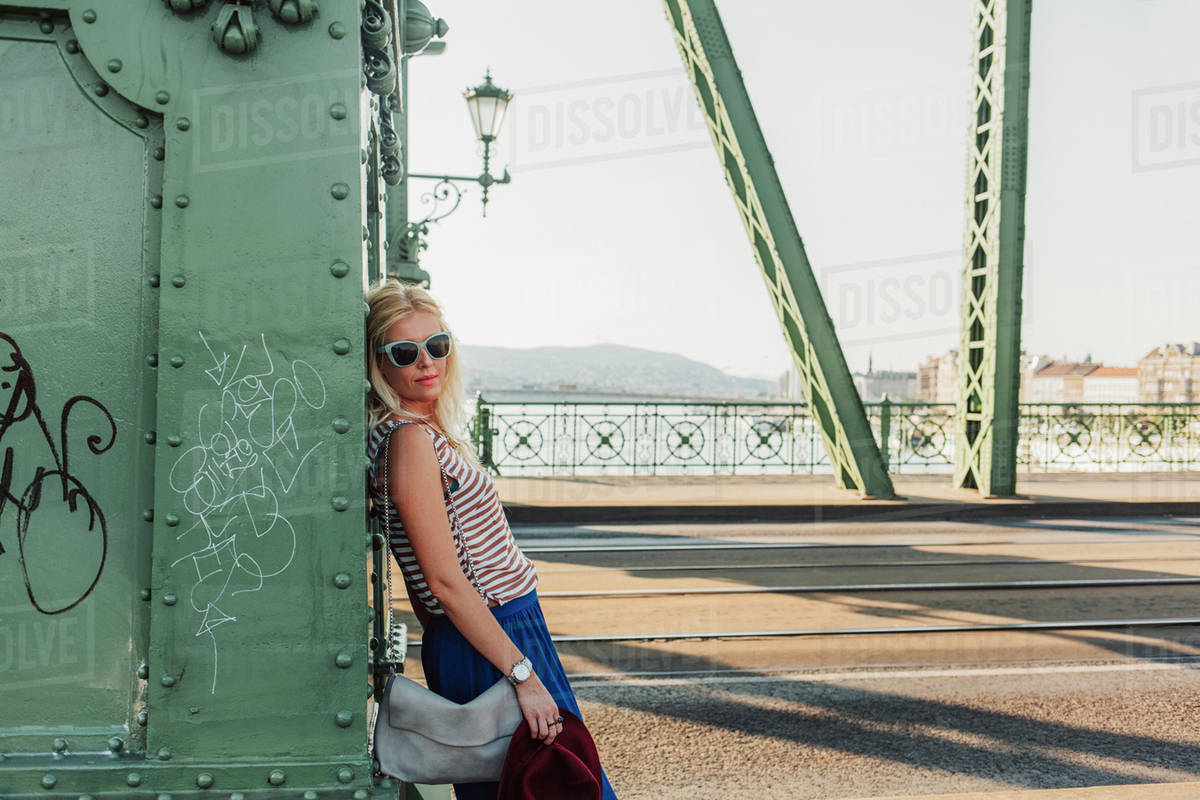 Caucasian woman standing on bridge - Stock Photo - Dissolve