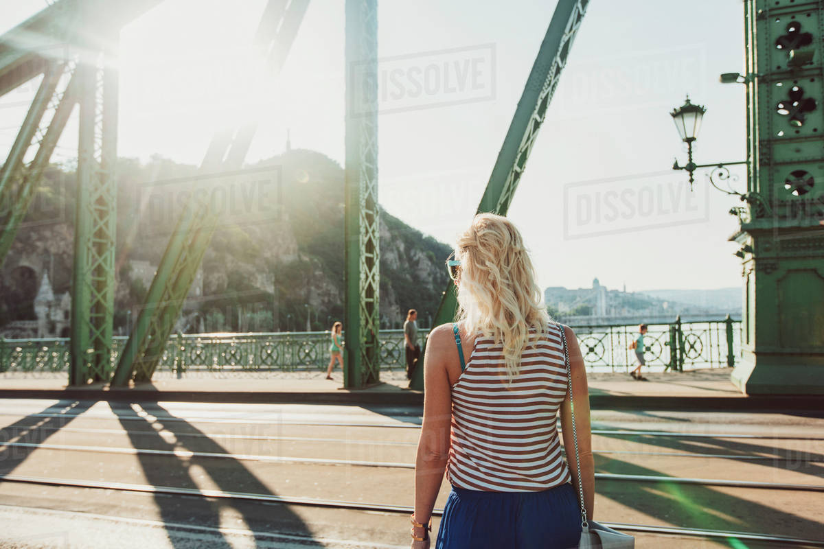 Caucasian woman standing on bridge - Stock Photo - Dissolve