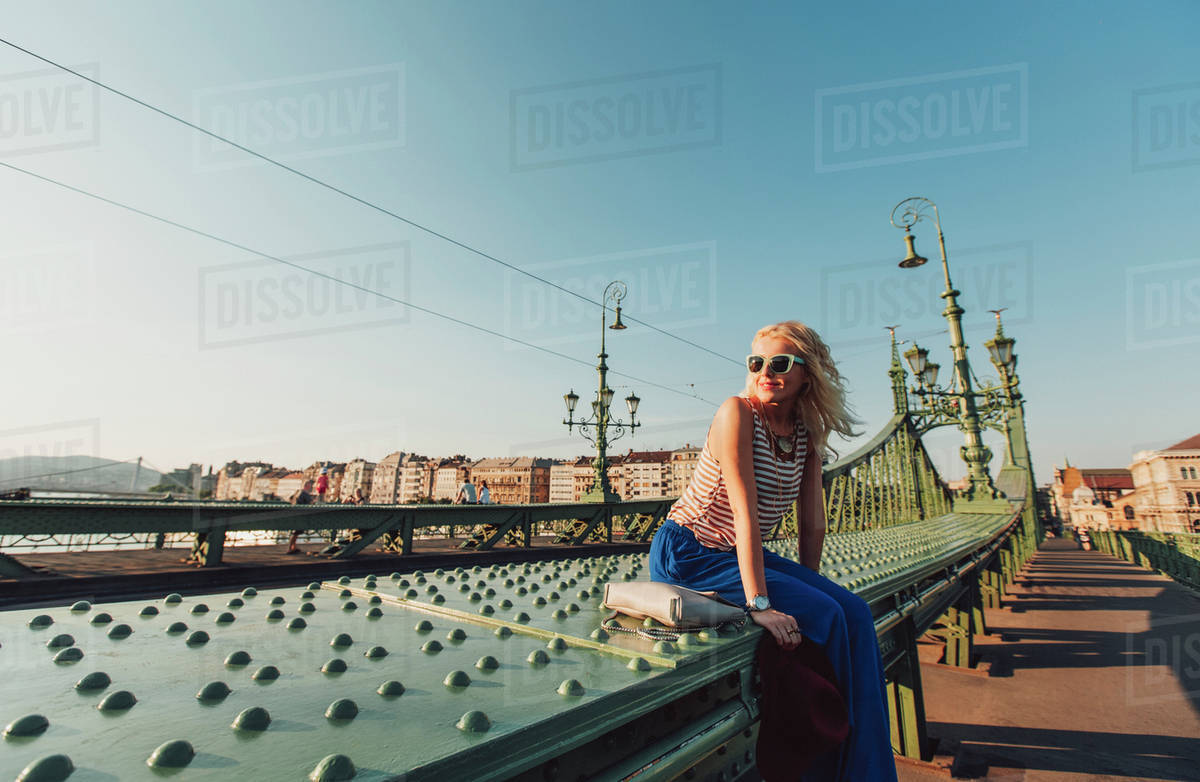 Caucasian woman sitting on bridge - Royalty-free Stock Photo | Dissolve