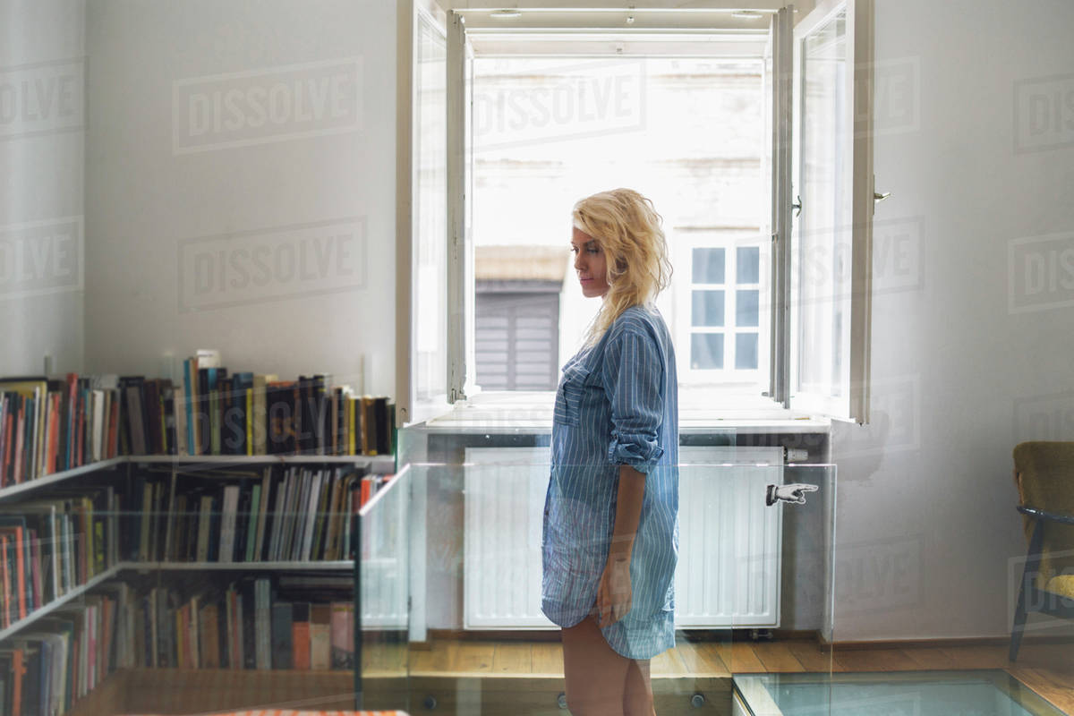 Woman standing in living room - Stock Photo - Dissolve