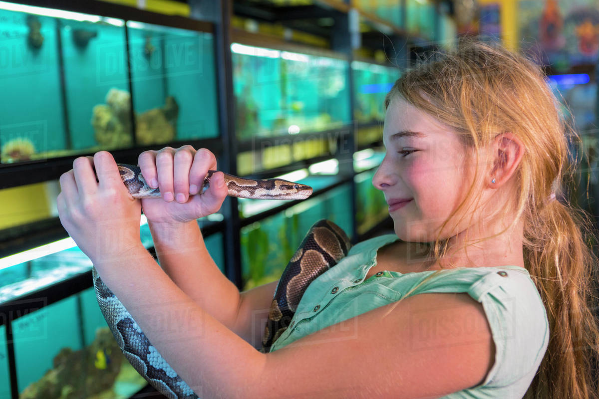 Caucasian girl admiring snake in pet store - Royalty-free Stock Photo ...
