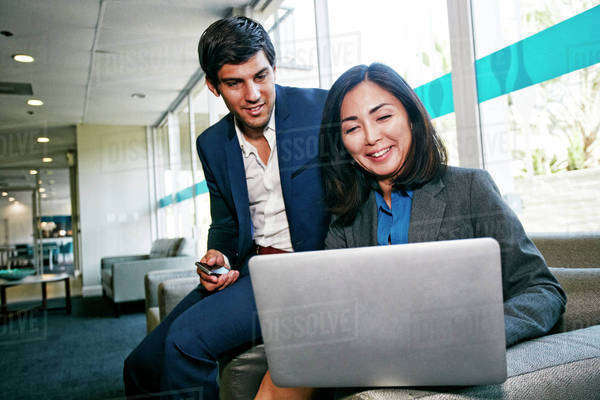 Business people using laptop in office - Stock Photo - Dissolve