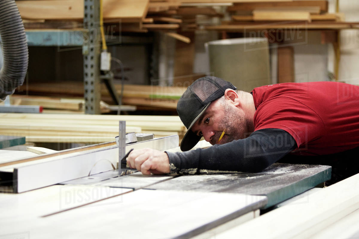 Carpenter using table saw in workshop - Royalty-free Stock Photo | Dissolve
