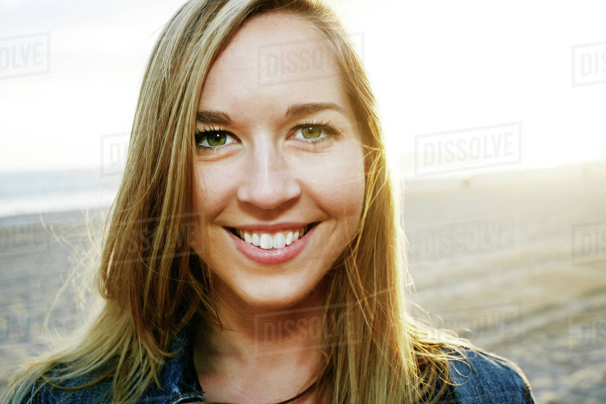 Caucasian woman smiling on beach - Royalty-free Stock Photo | Dissolve