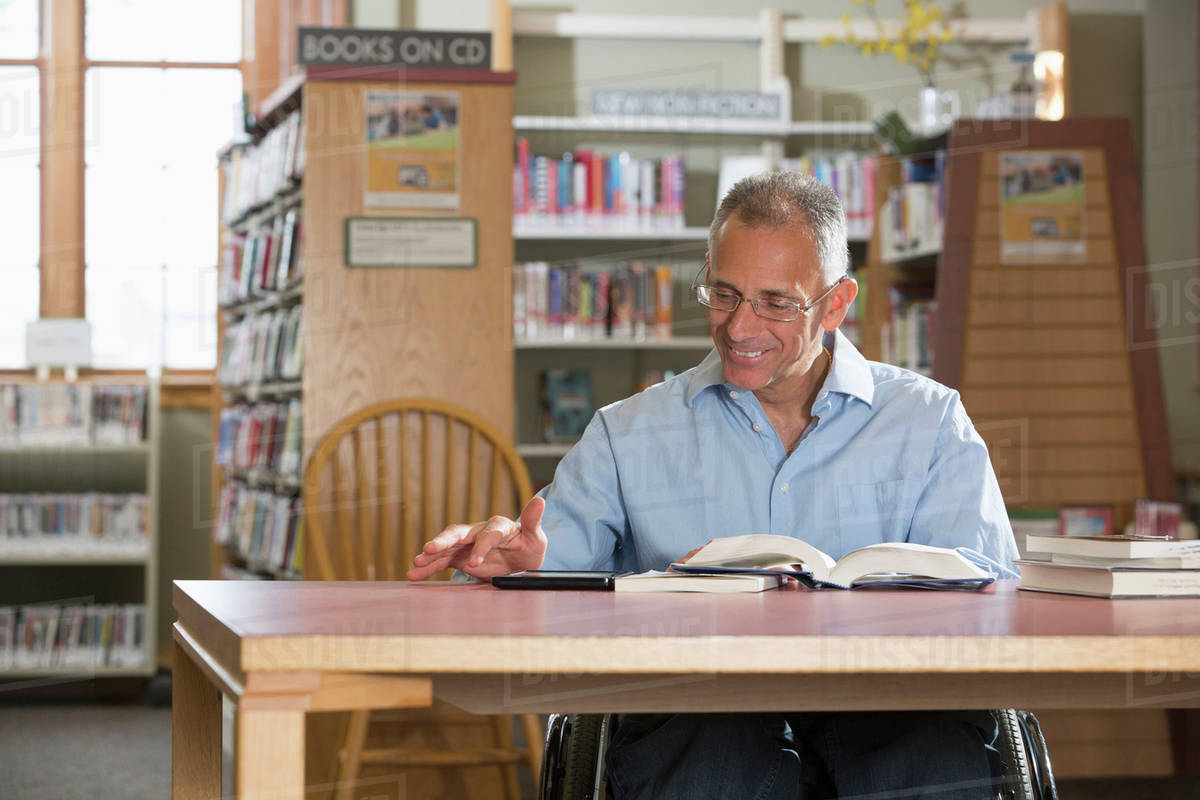 Caucasian man reading in library - Stock Photo - Dissolve