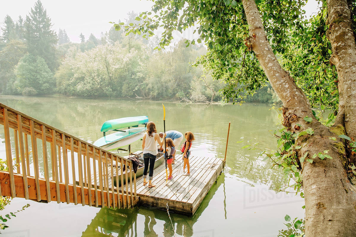 Family standing on dock in lake - Stock Photo - Dissolve