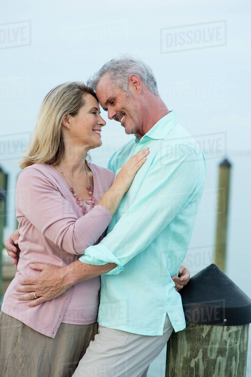 Older Caucasian woman hugging on pier - Royalty-free Stock Photo | Dissolve