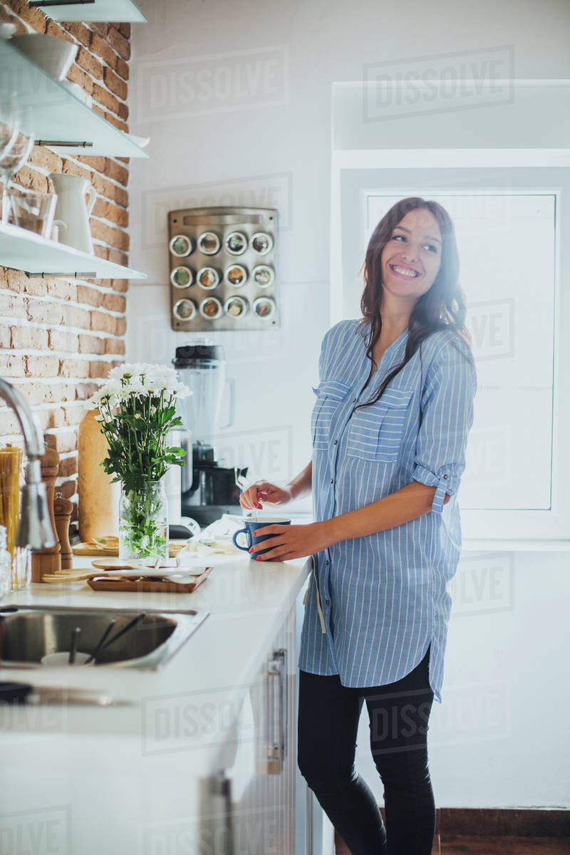 Caucasian woman smiling in kitchen - Royalty-free Stock Photo | Dissolve