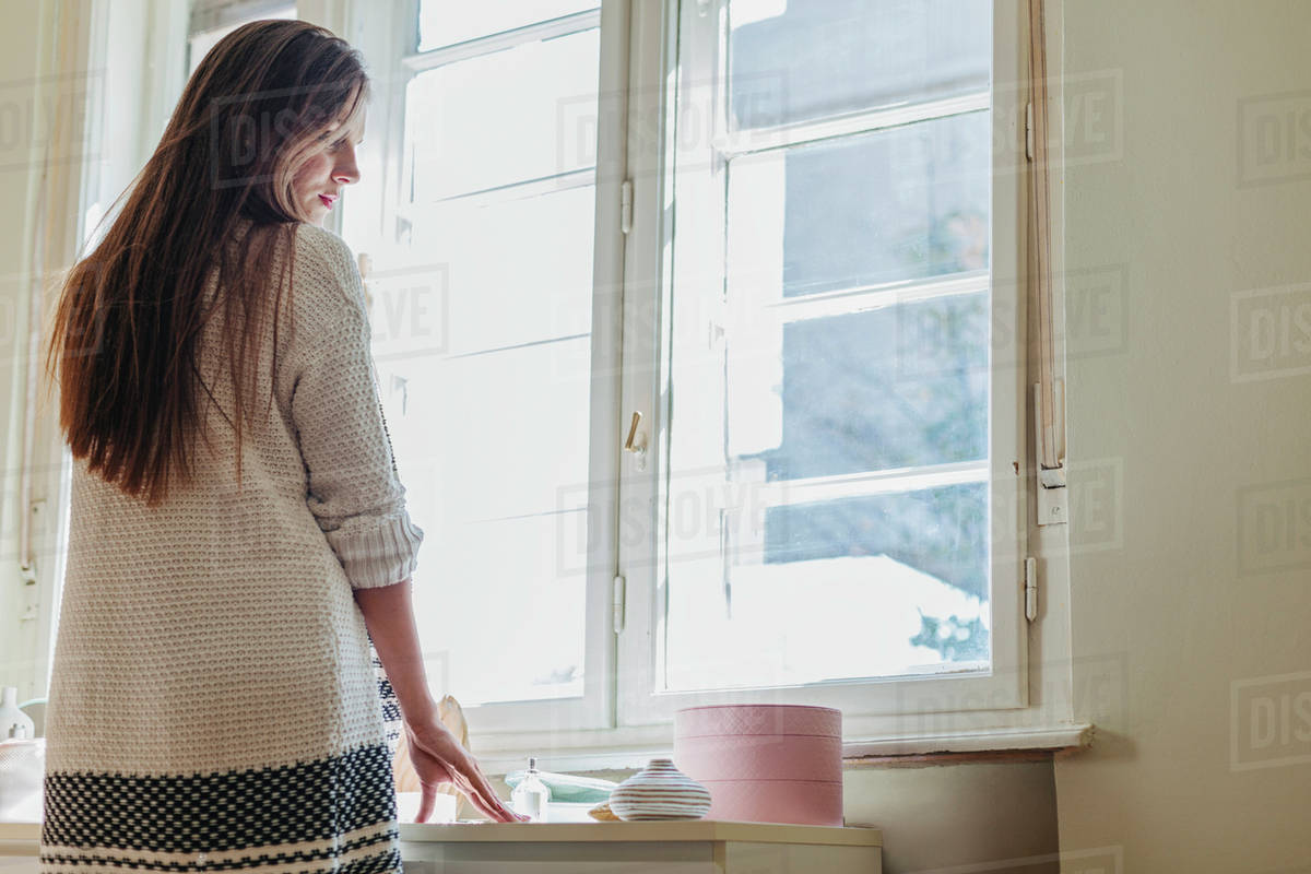 Caucasian woman standing at window - Stock Photo - Dissolve