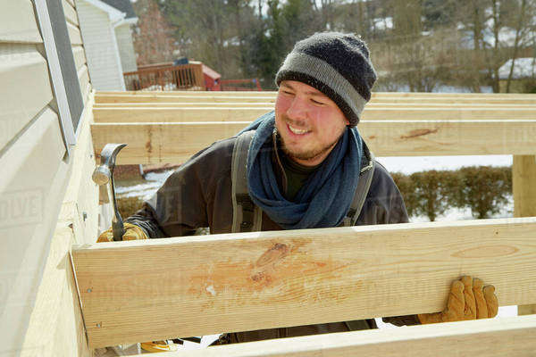 Caucasian carpenter building house extension in winter - Stock Photo ...