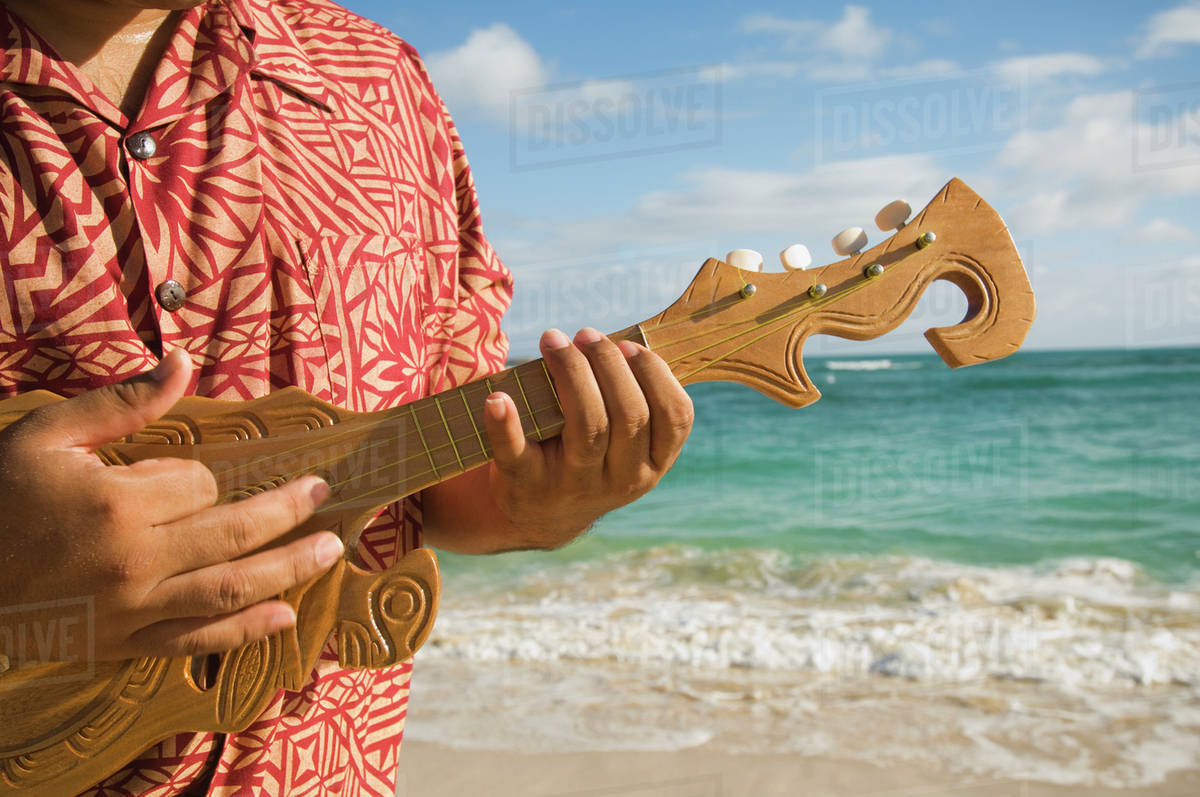 Pacific Islander man playing instrument at beach - Royalty-free Stock ...