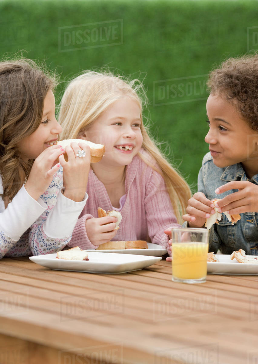 Multi-ethnic girls eating sandwiches - Royalty-free Stock Photo | Dissolve