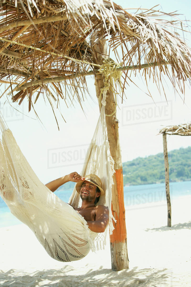 Hispanic man laying in hammock - Royalty-free Stock Photo | Dissolve