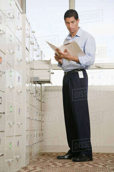 Mixed race businessman looking at files - Royalty-free Stock Photo ...