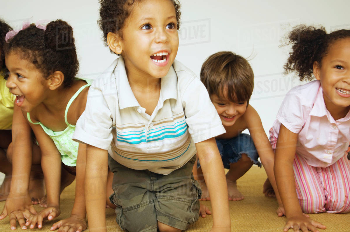 Multi-ethnic children kneeling and smiling - Royalty-free Stock Photo ...