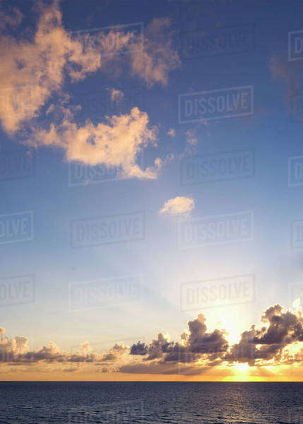 Sun setting over ocean - Royalty-free Stock Photo | Dissolve