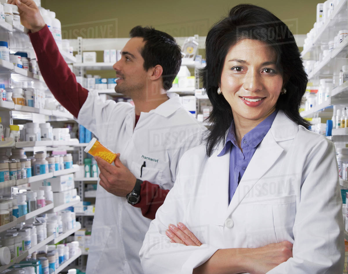 Asian pharmacist in front of coworker - Royalty-free Stock Photo | Dissolve