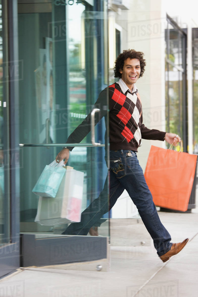 Middle Eastern man leaving store with shopping bags - Royalty-free ...