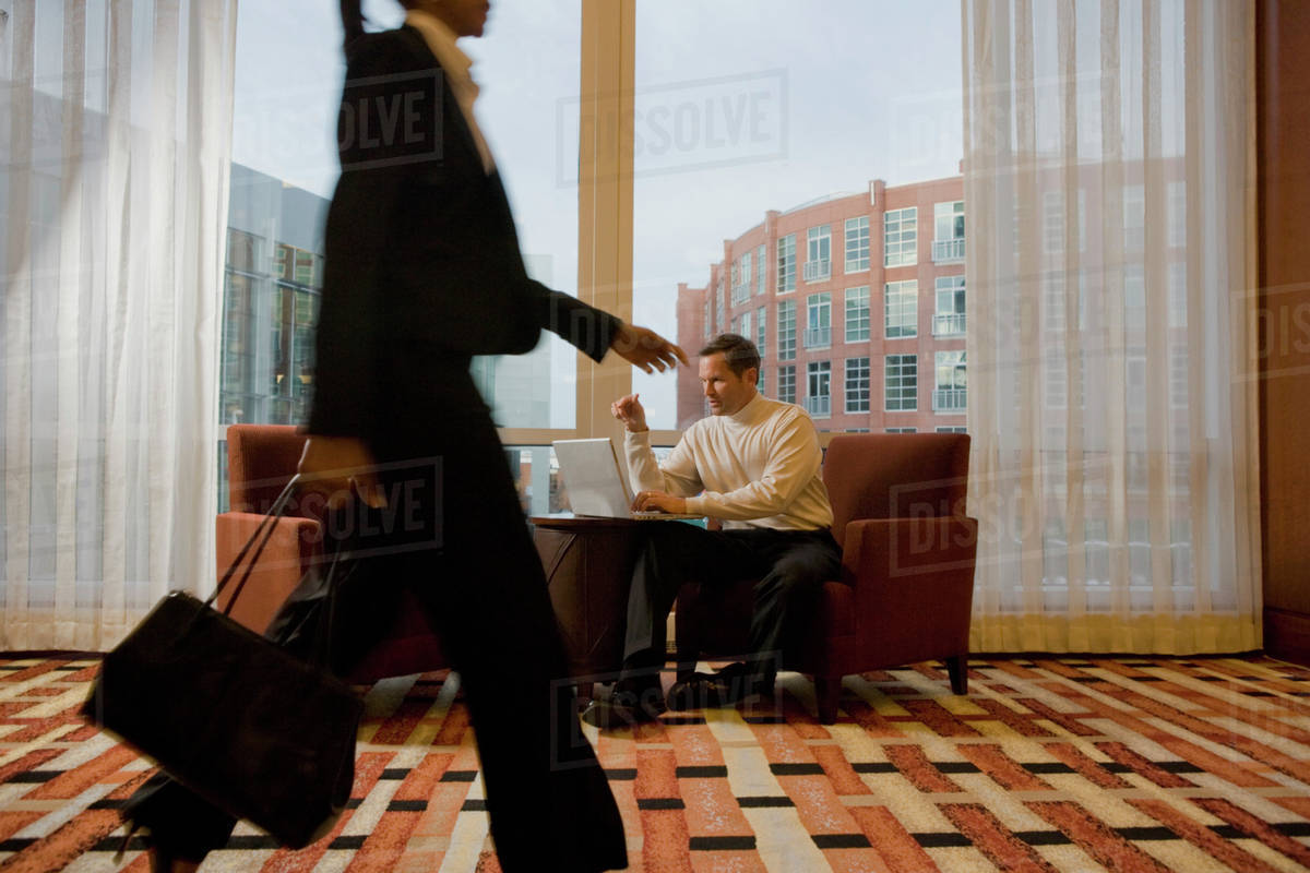 Businessman working on laptop in waiting area near window - Stock Photo ...