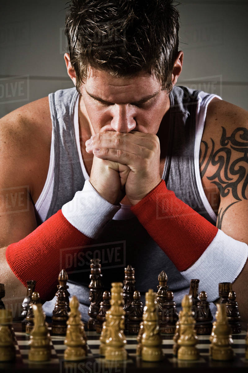 Body builder playing chess - Stock Photo - Dissolve