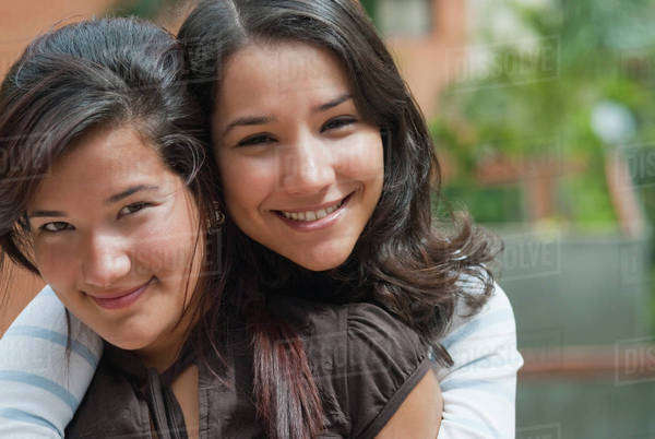 Hispanic sisters hugging - Royalty-free Stock Photo | Dissolve