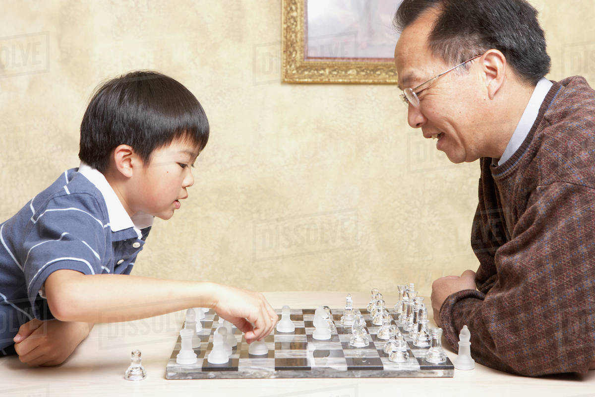 Asian father and young son playing chess - Royalty-free Stock Photo ...