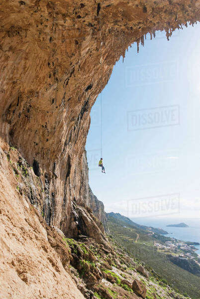 Caucasian climber hanging from cable on rock wall - Royalty-free Stock ...