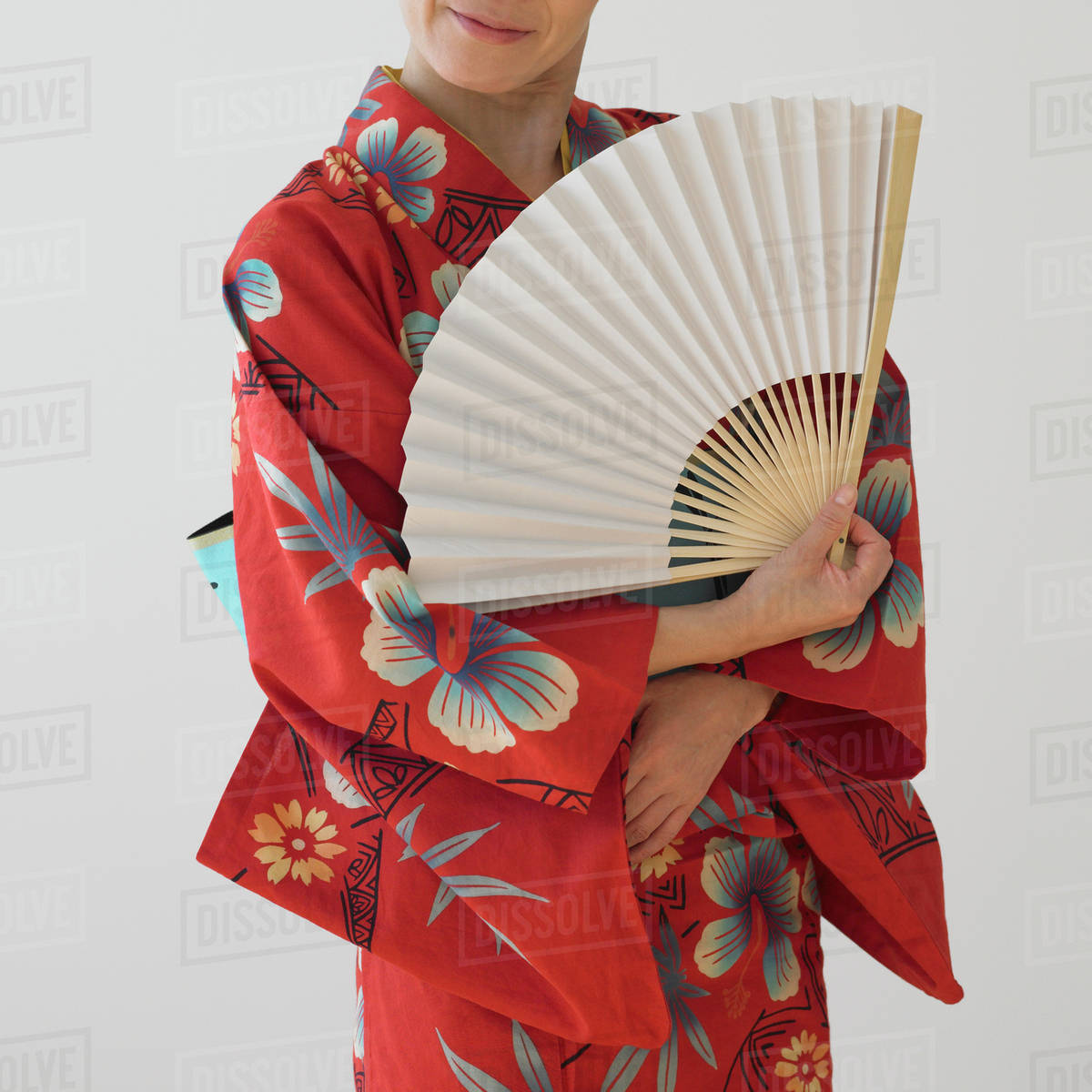 Asian woman in traditional dress holding fan - Stock Photo - Dissolve