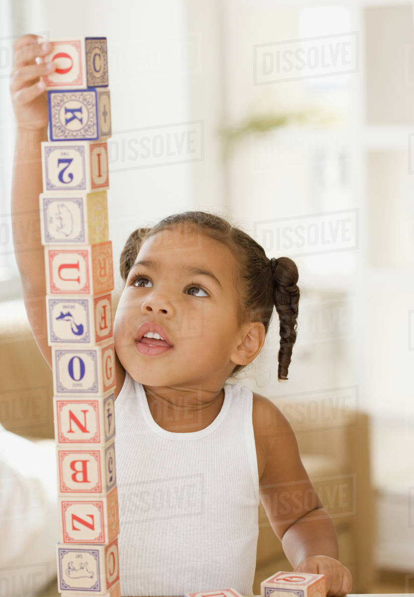 African girl building tower of blocks - Royalty-free Stock Photo | Dissolve