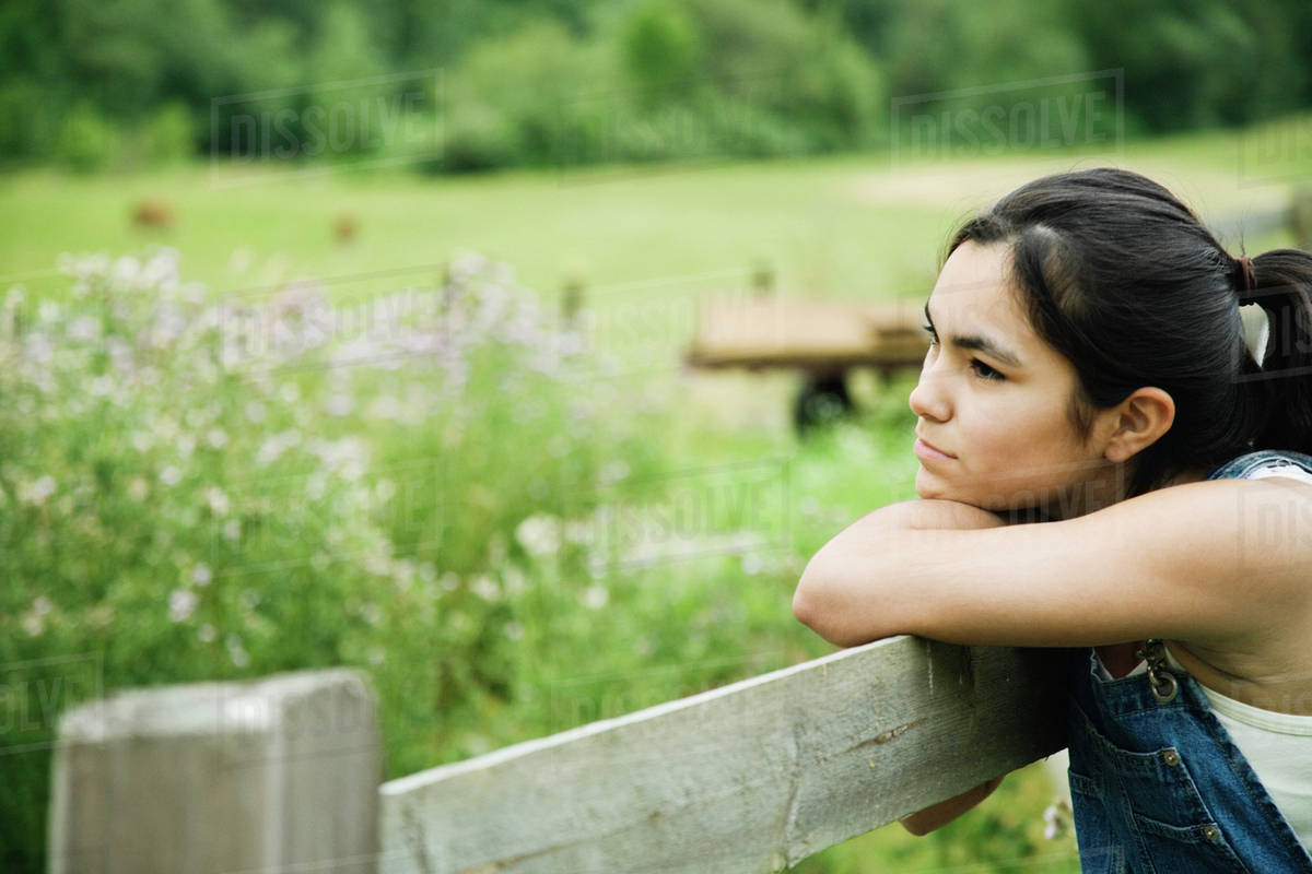 Girl leaning on wooden fence - Royalty-free Stock Photo | Dissolve