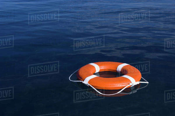 Round life preserver floating in water - Stock Photo - Dissolve