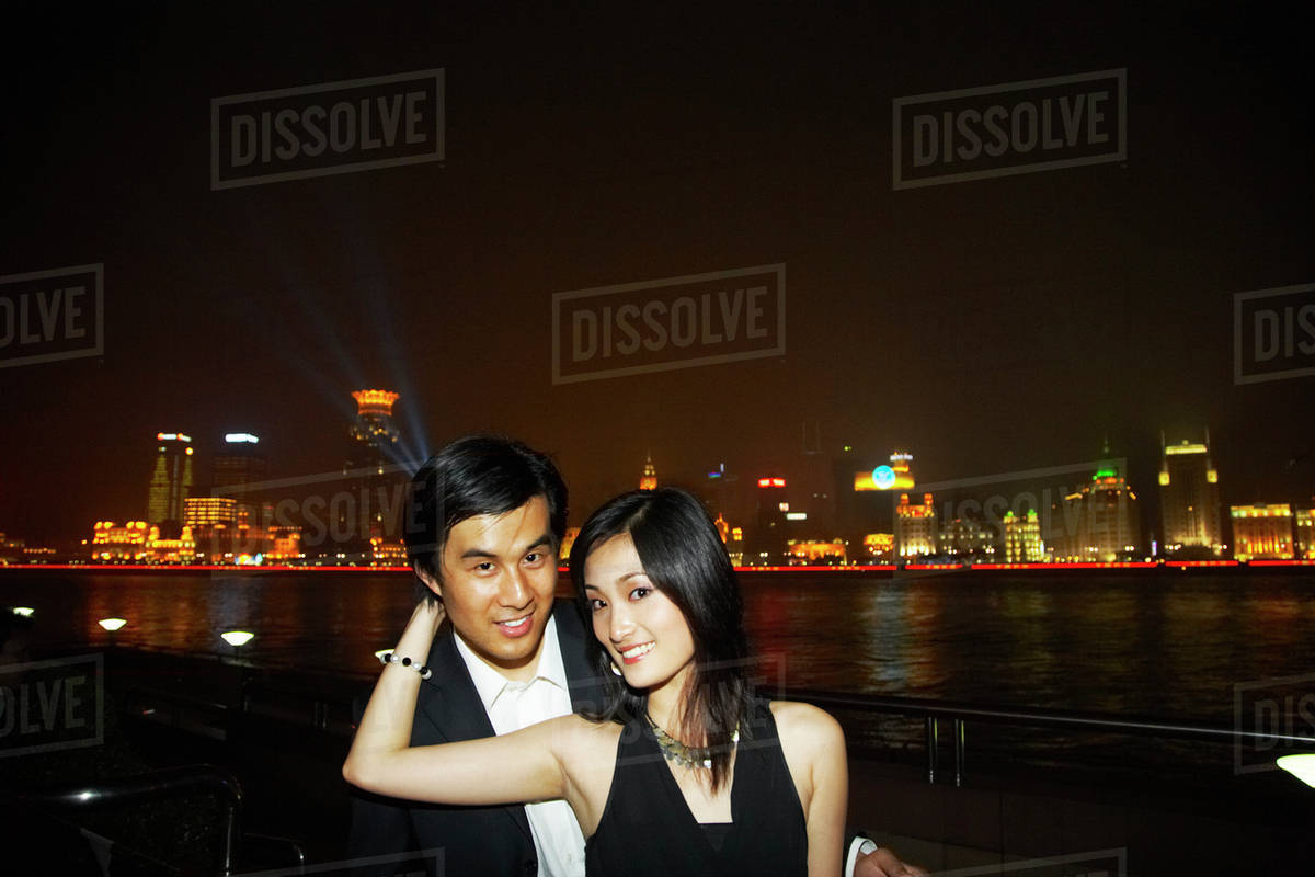 Chinese couple hugging on city waterfront - Stock Photo - Dissolve