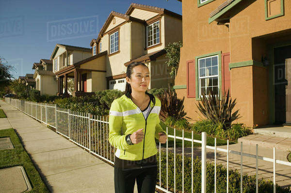 Woman jogging in neighborhood - Stock Photo - Dissolve