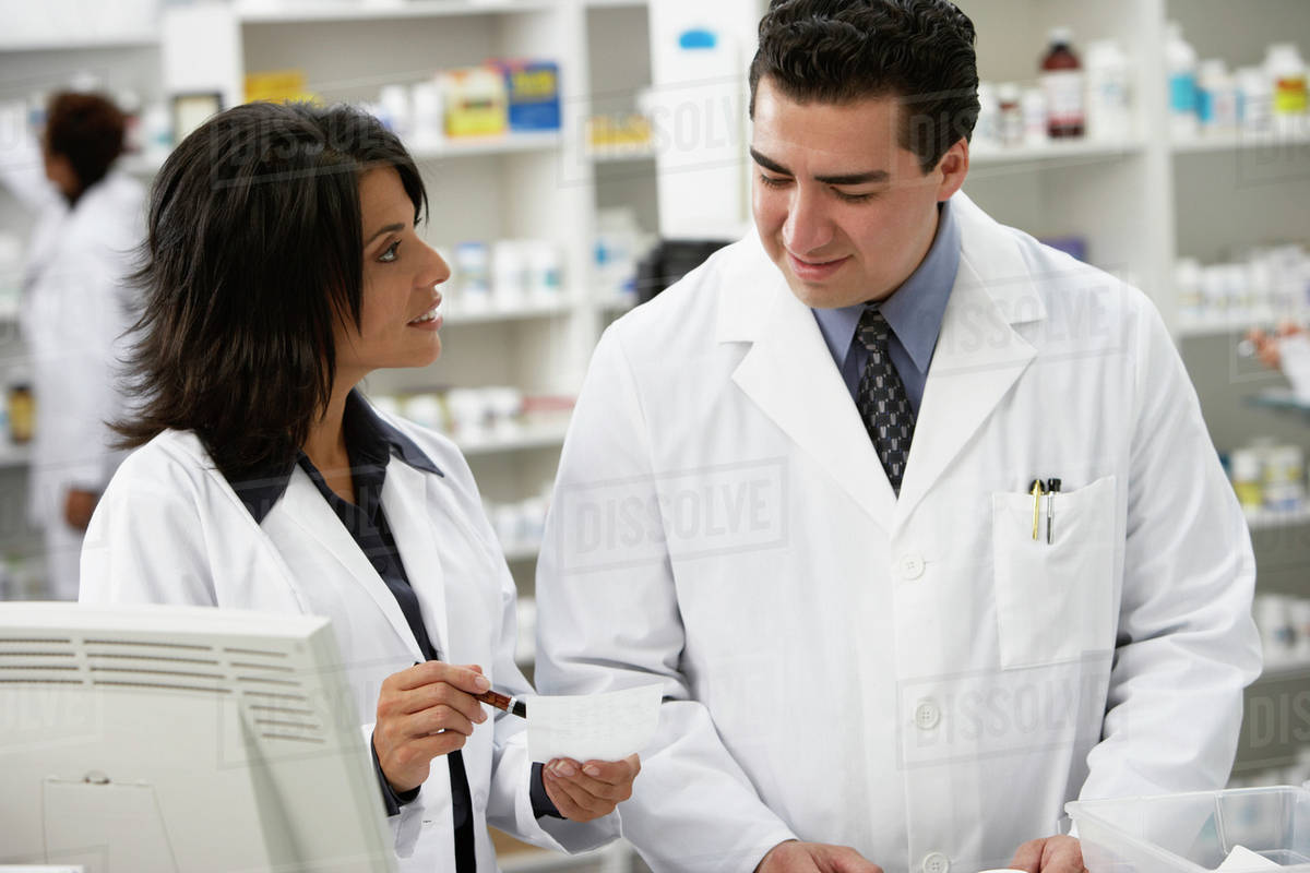 Pharmacists talking in pharmacy - Stock Photo - Dissolve