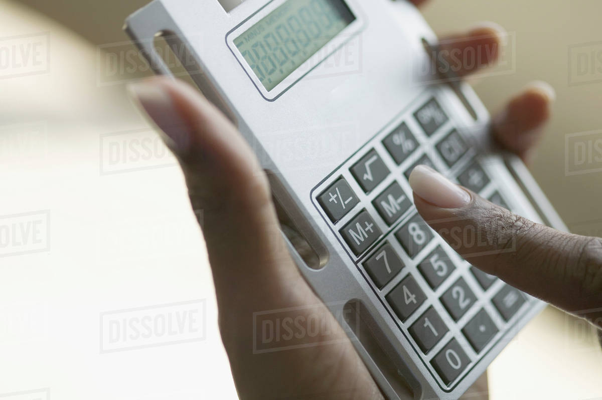 Close up of hands holding calculator - Royalty-free Stock Photo | Dissolve