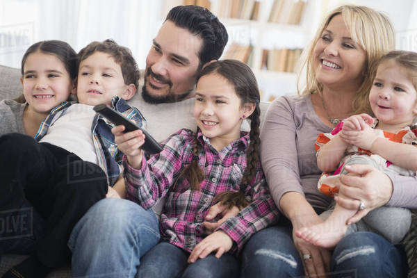 Caucasian parents and children smiling in living room - Stock Photo ...