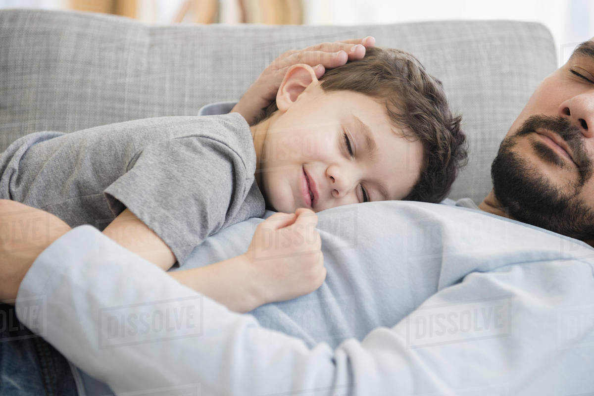 Caucasian father and son napping on sofa - Royalty-free Stock Photo ...
