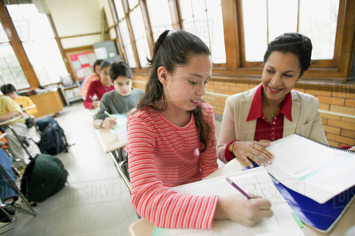 Hispanic school teacher helping student - Royalty-free Stock Photo ...