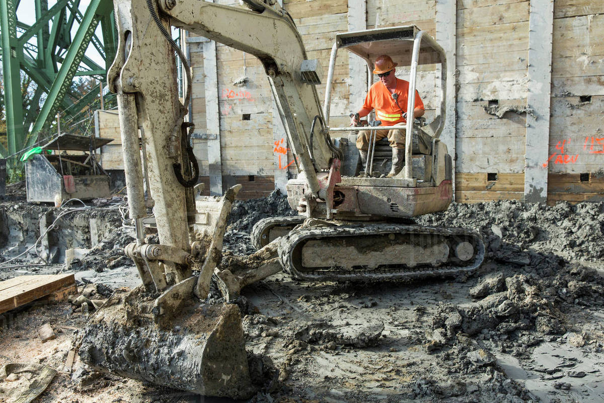 Caucasian worker using digger at construction site - Royalty-free Stock ...