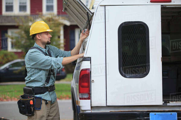 Caucasian worker pulling equipment from truck - Royalty-free Stock ...