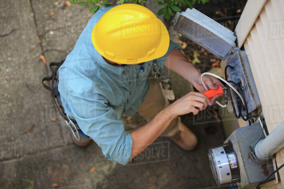 Caucasian worker installing cable box - Royalty-free Stock Photo | Dissolve