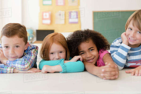 Students smiling in classroom - Stock Photo - Dissolve